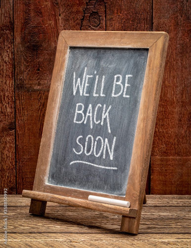 We will be back soon - white chalk handwriting on a blackboard ...