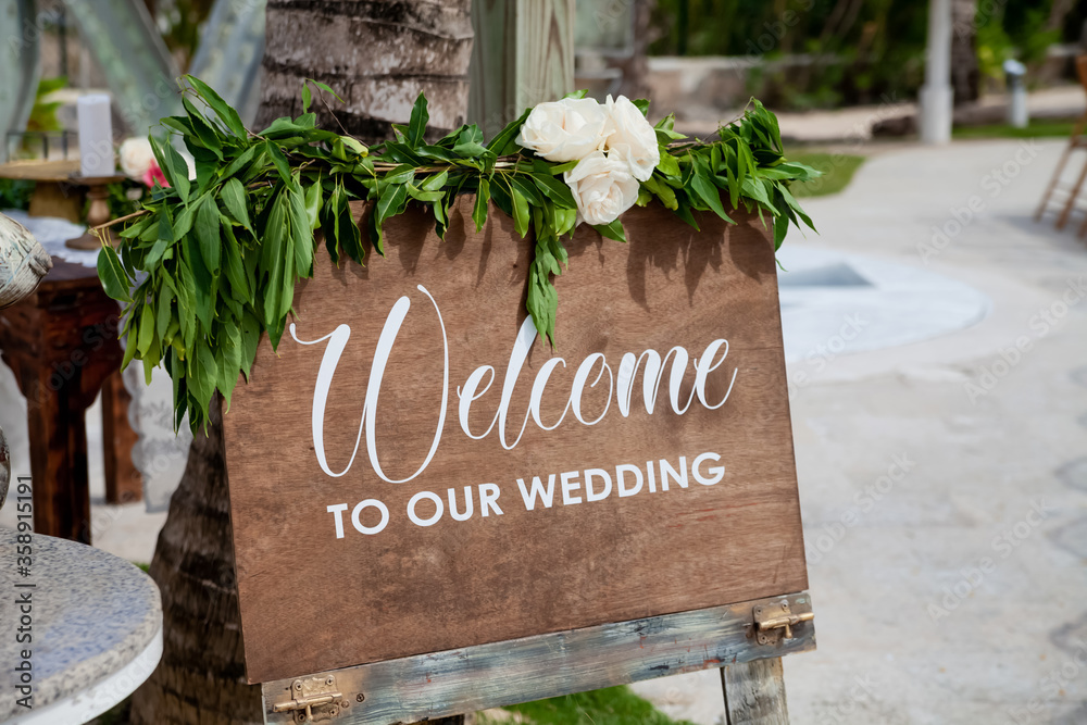 Wooden welcome table board sign at the wedding on the beach with ...