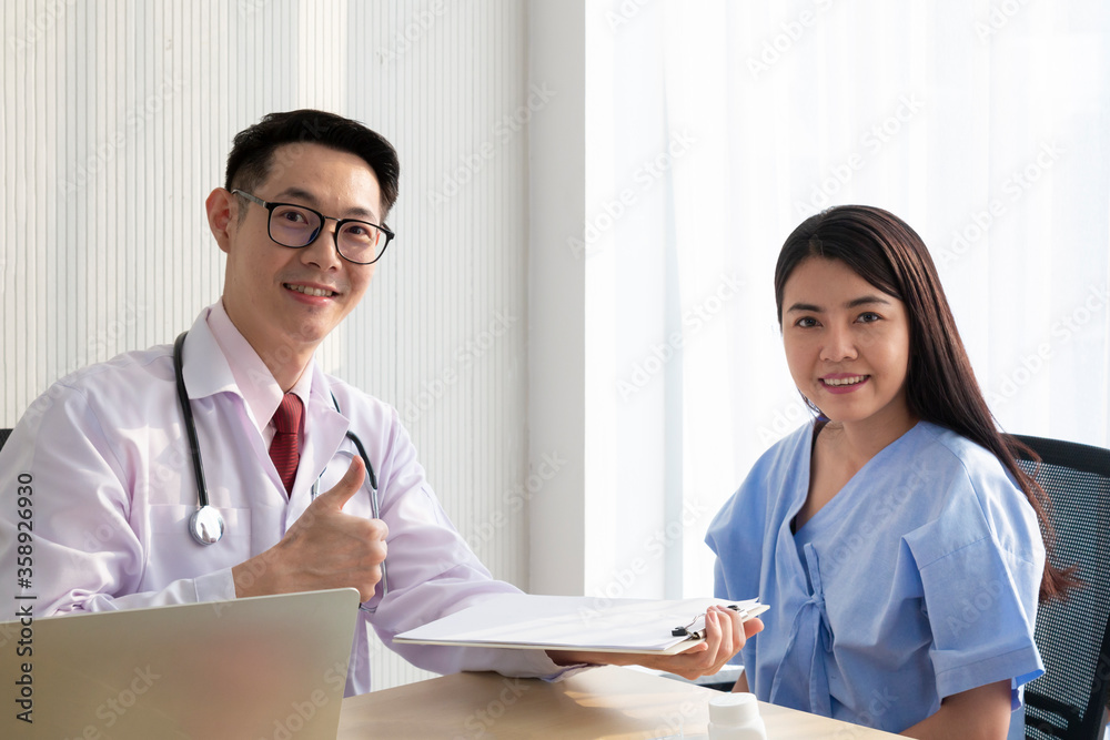 Charming male doctor giving advice to a female patient. Doctor working ...