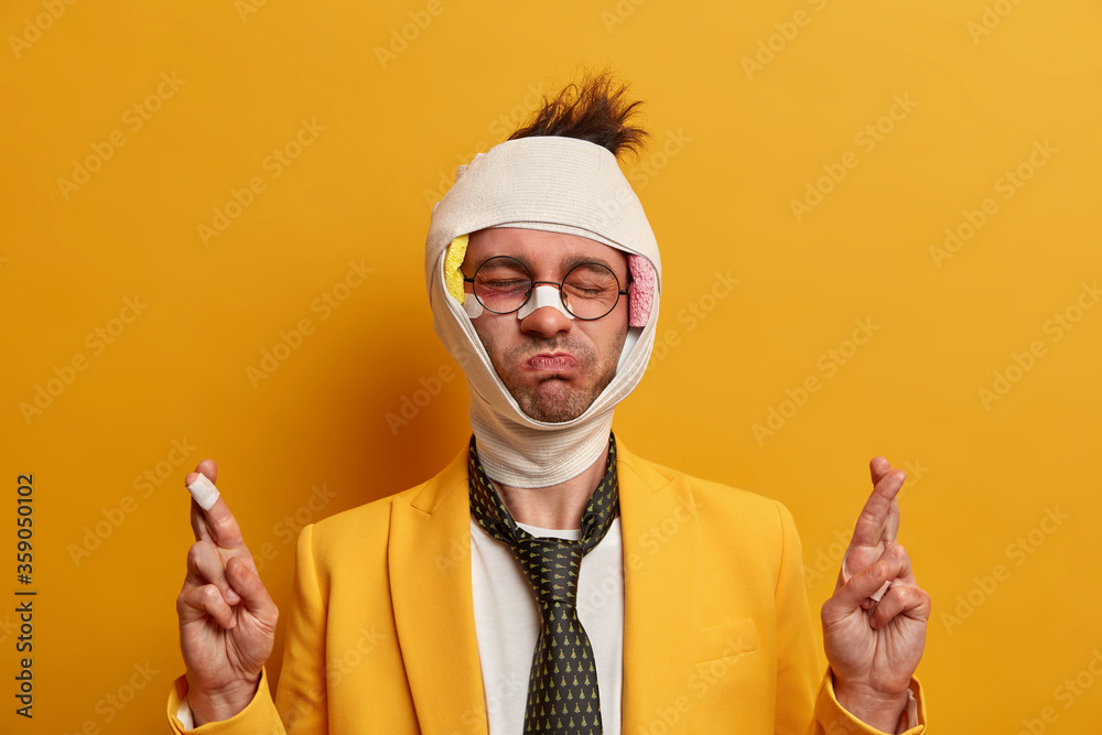 Funny young man crosses fingers and prays for recovery, being hit by ...