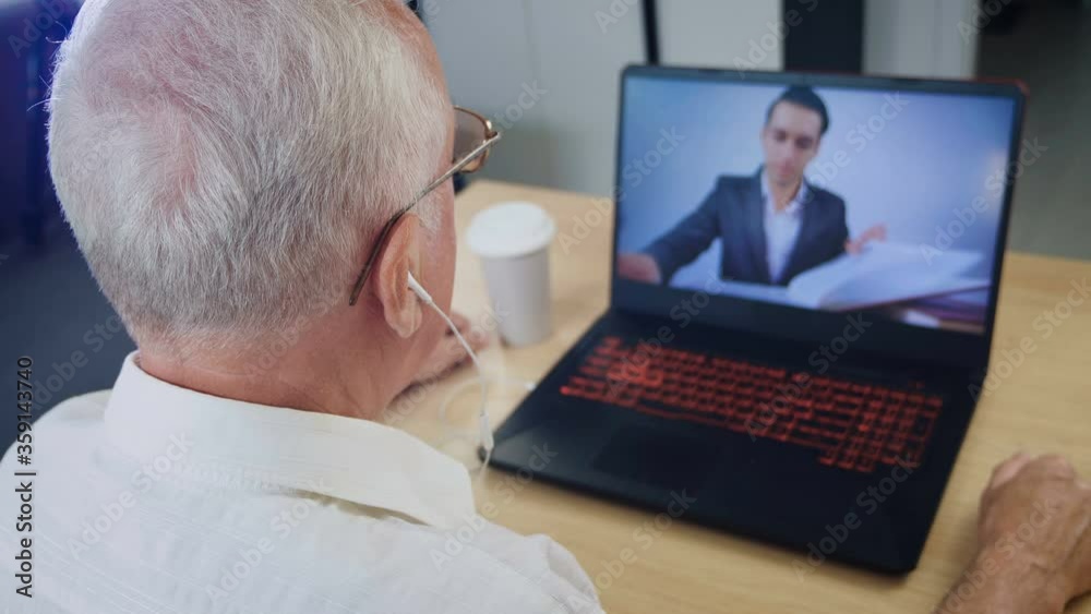 Senior man having video conference on his laptop. Online webinar or ...