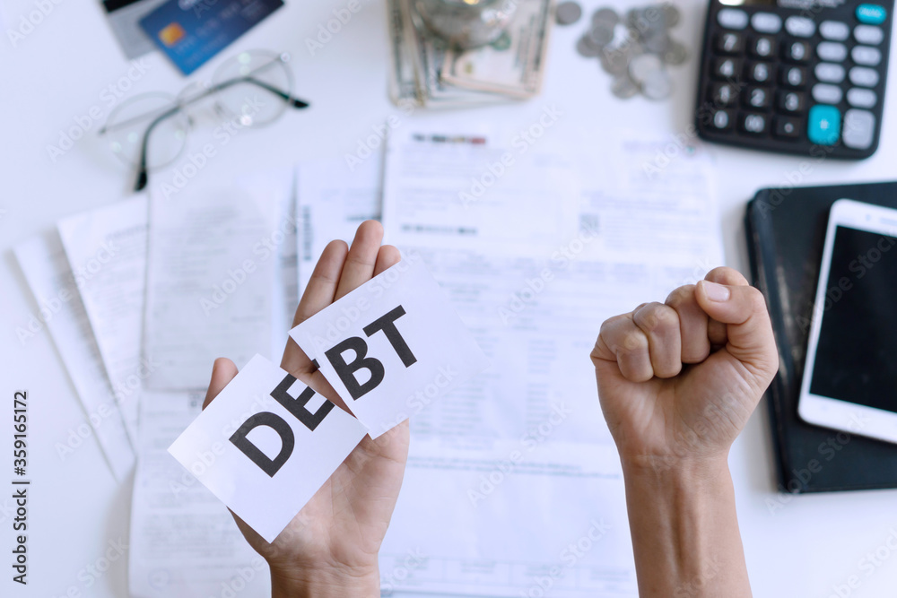 woman hands holding up a piece of paper with the word debt written on ...