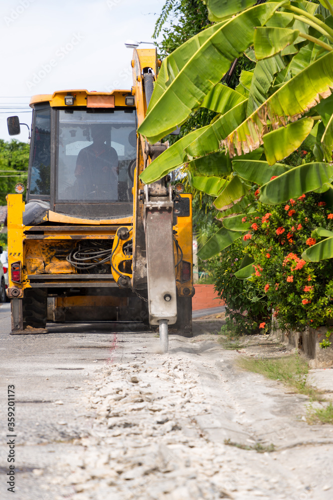 Excavator breaking and drilling the concrete road for repairing. Large ...