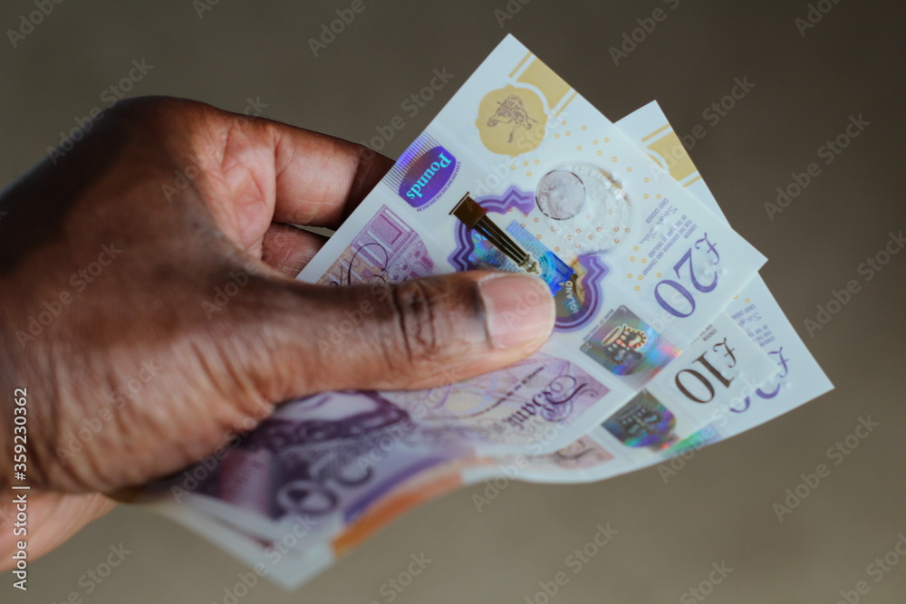 hand holding a number of pound notes depicting increase in electronic ...
