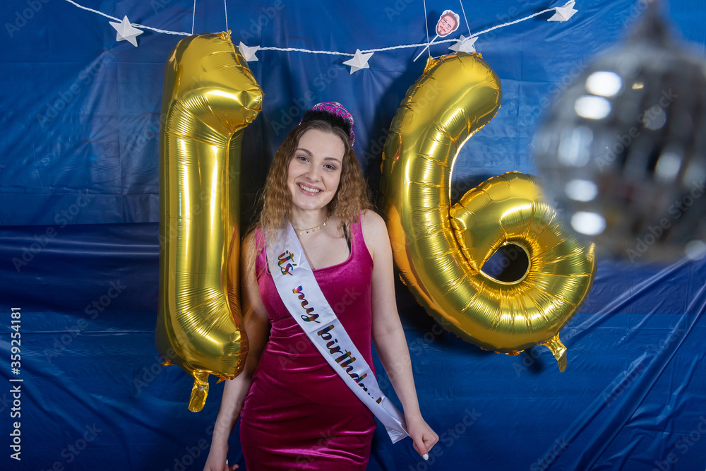 Sixteen year old girl wearing a tiara and sash celebrates her birthday ...