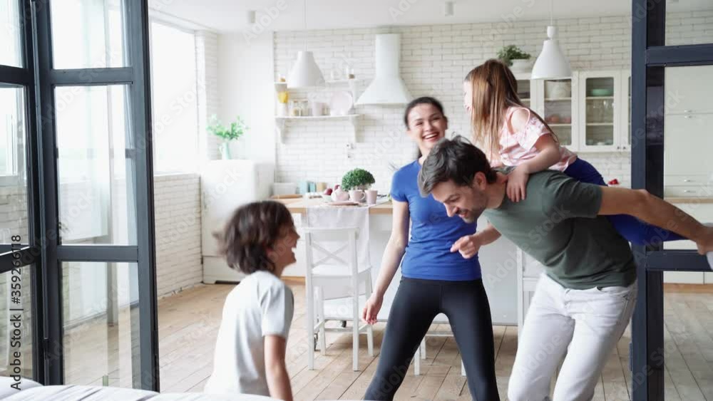Crazy happy family, young parents and two cute little kids playing ...