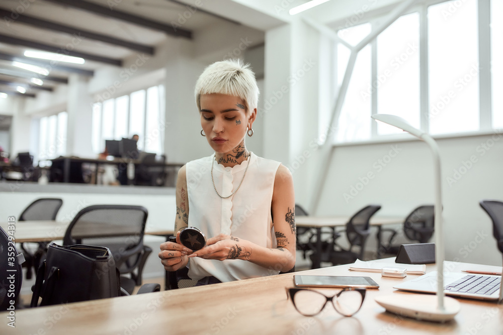 Beautiful woman at work. Portrait of young and cute blonde tattooed ...