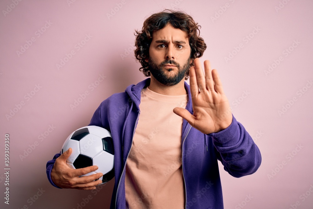 Handsome player man with beard playing soccer holding football ball ...