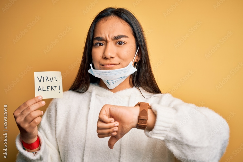 Young beautiful asian woman wearing medical mask holding paper with ...