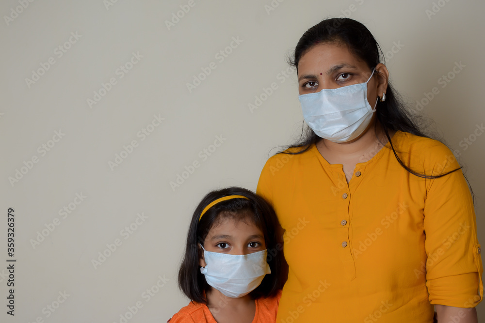 a mother and her daughter with wearing mask for protection of corona ...