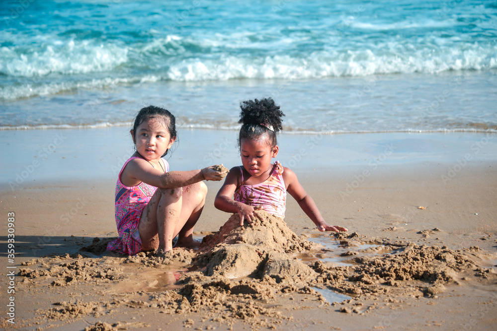 Cute kids having fun on sandy summer beach with blue sea, happy ...