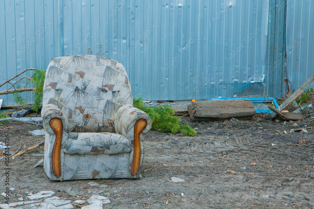 an old ragged chair in the trash. garbage collapse. furniture ...