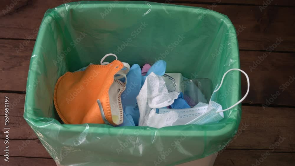 Used face masks and gloves throwaway in trash can. Plastic pollution ...