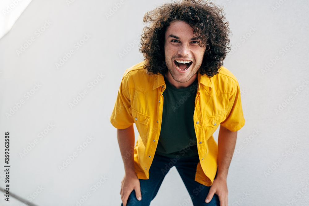 Half-length image of cheerful handsome man with curly hair smiling ...