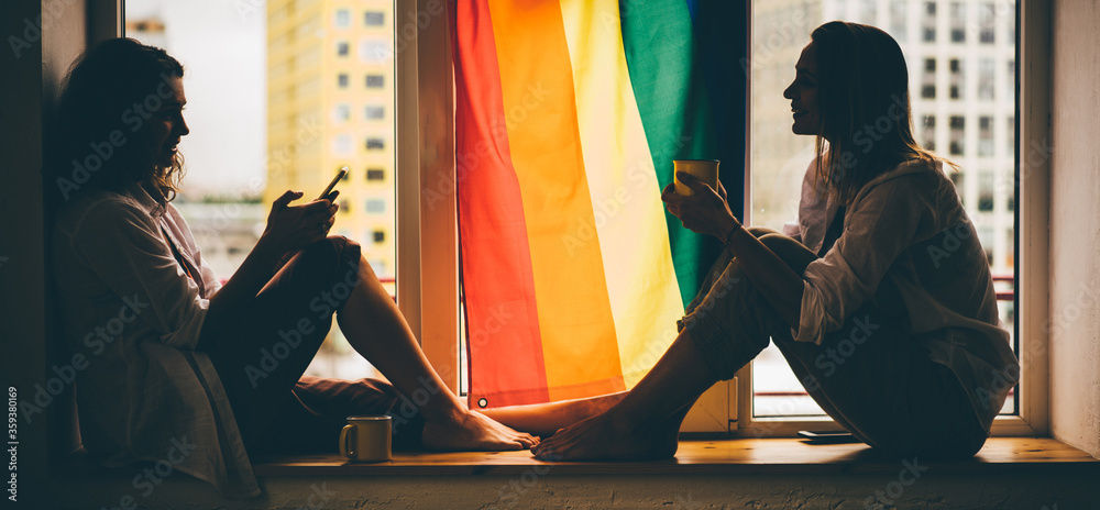 Two beautiful female young lesbian couple in silhouette sitting near ...