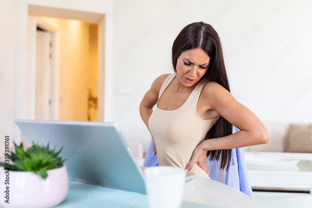 Upset young woman feels back pain massaging aching muscles, sad lady ...