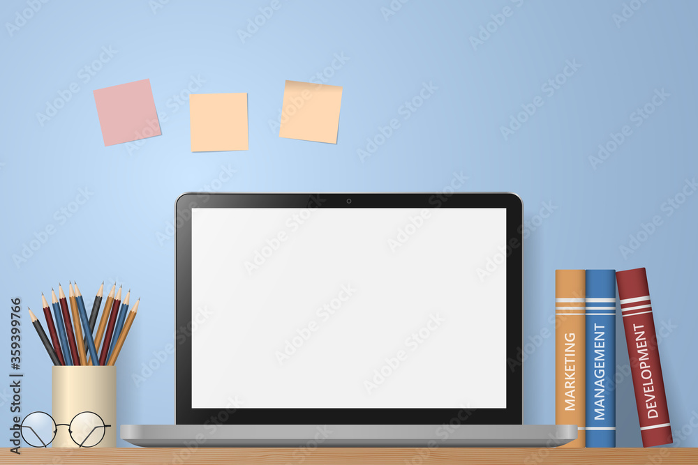 Workspace with laptop, business books and pencils on blue wall ...