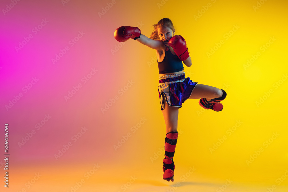 Little caucasian girl, kick boxer on gradient background in neon light ...