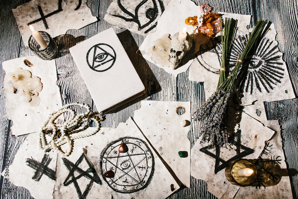 White magic book laying on the table with old manuscripts with occult ...