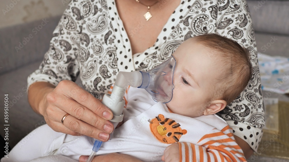 Infant getting breathing treatment from mother while suffering from ...