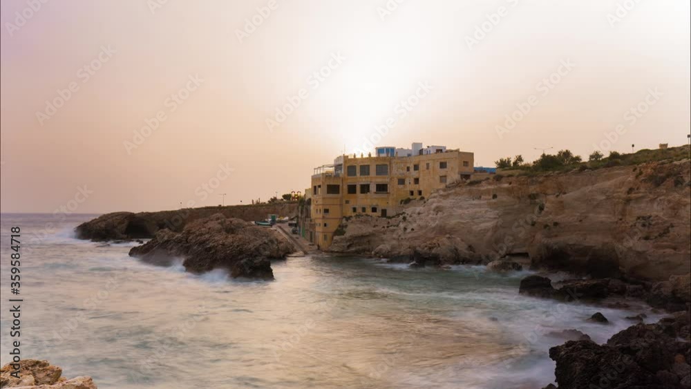 Sun setting behind the buildings at Ghar Lapsi, Siggiewi Malta with the ...