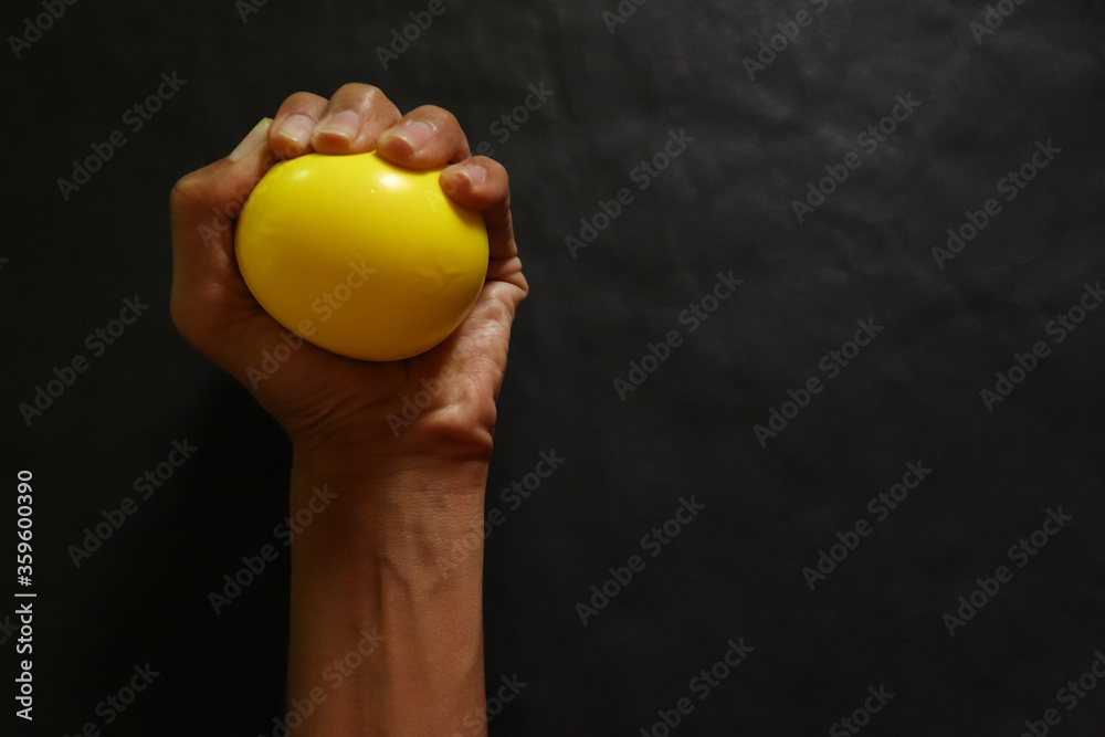 Hand of a man squeezing a stress ball to reduce stress and pressure to ...