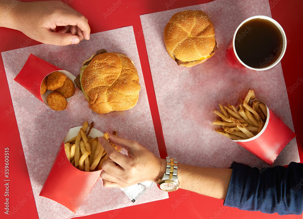 Flat top view of red table with hands picking on food friends sharing ...