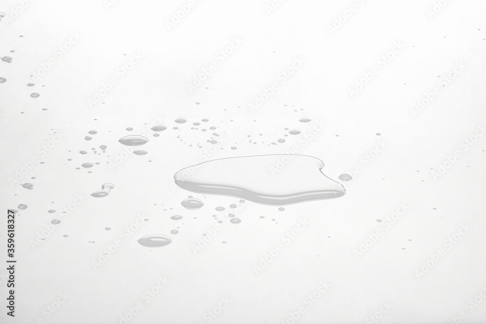 Water puddles and droplets on white reflective surface. Frontal view ...