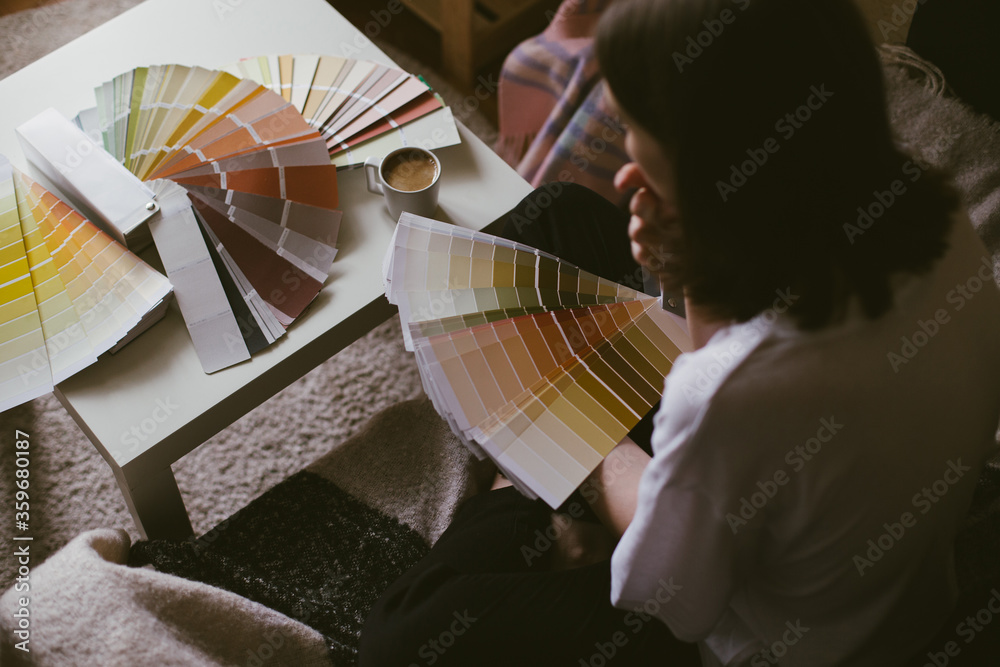 Woman choosing paint color from swatches and palette for house ...
