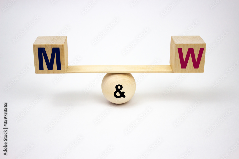M and W letters on wooden cubes. The concept of gender equality. Man ...
