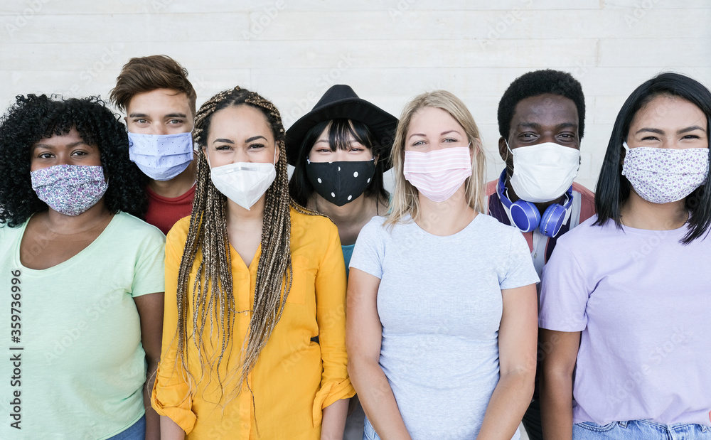 Happy multiracial friends laughing and wearing protective face mask ...