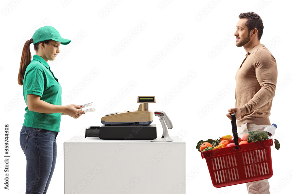 Man with a shopping basket at a cash register and a female cashier ...