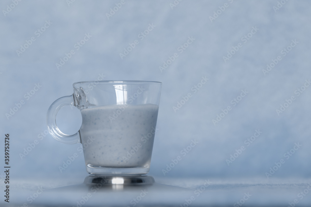 Small portion of blueberry smoothie on tiny glass teacup saucer ...