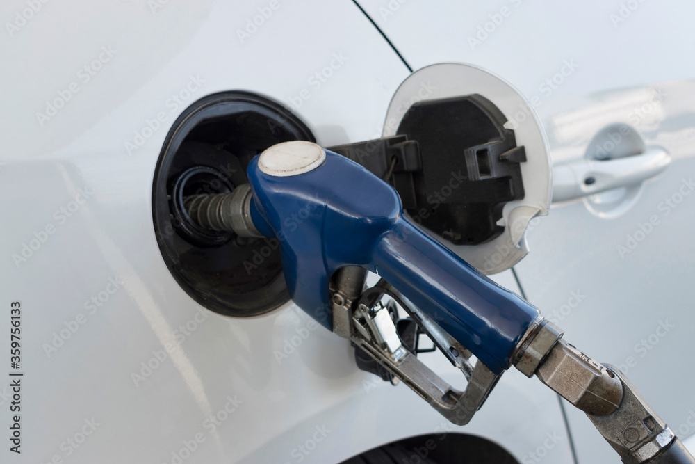 Refueling car at a gas station. Car fuel tank and gas pump. Close-up of ...