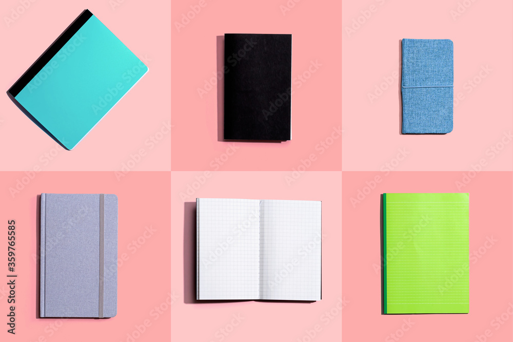 Variety of notebooks and notepads on tiled desk flatlay from above ...