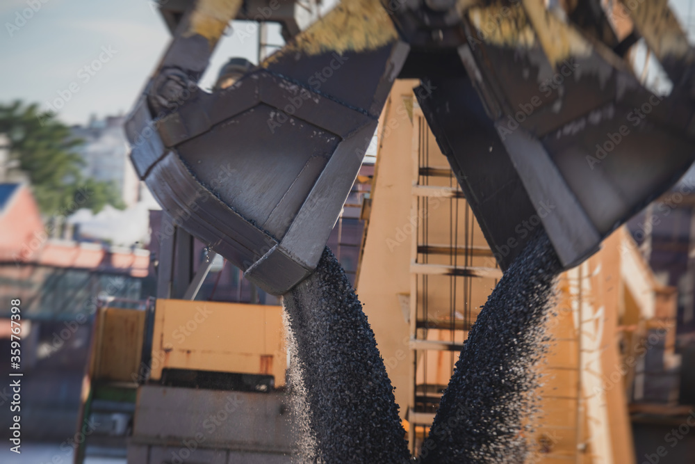 Bulk-handling crane unloading sand, road metal and gravel from cargo ...