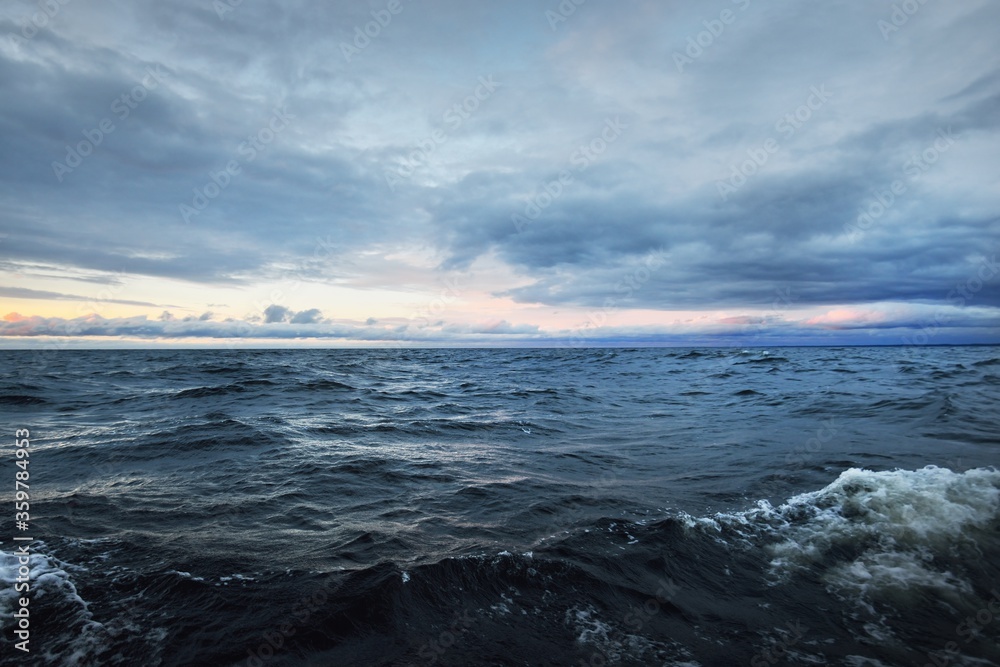A view to the North sea from a sailing boat at sunset. Dramatic stormy ...