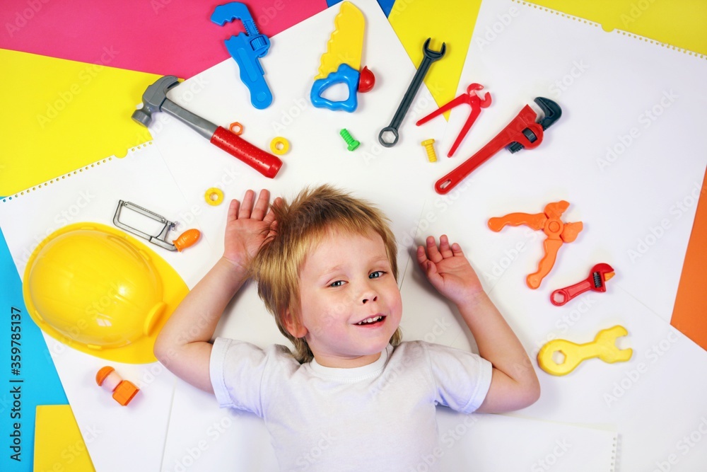 Cute little boy surrounded by toy tools top view. Happy boy playing ...