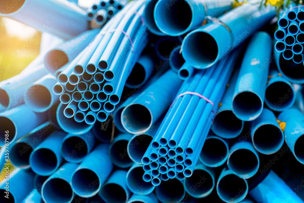 Selective to blue plastic pipe background. PVC pipes stacked in ...