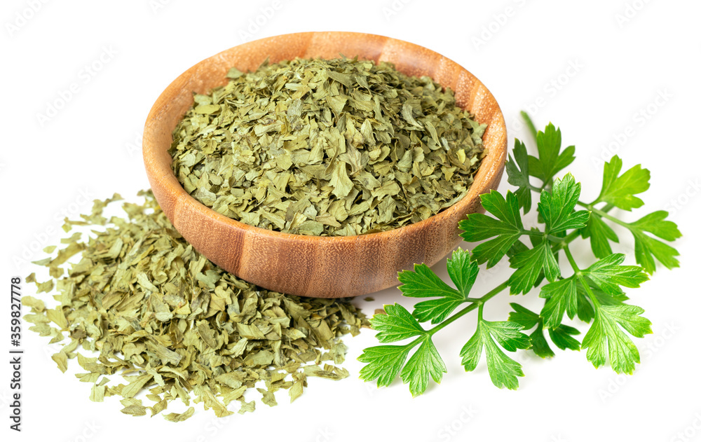 dried parsley flakes in the wooden bowl, isolated on white background ...