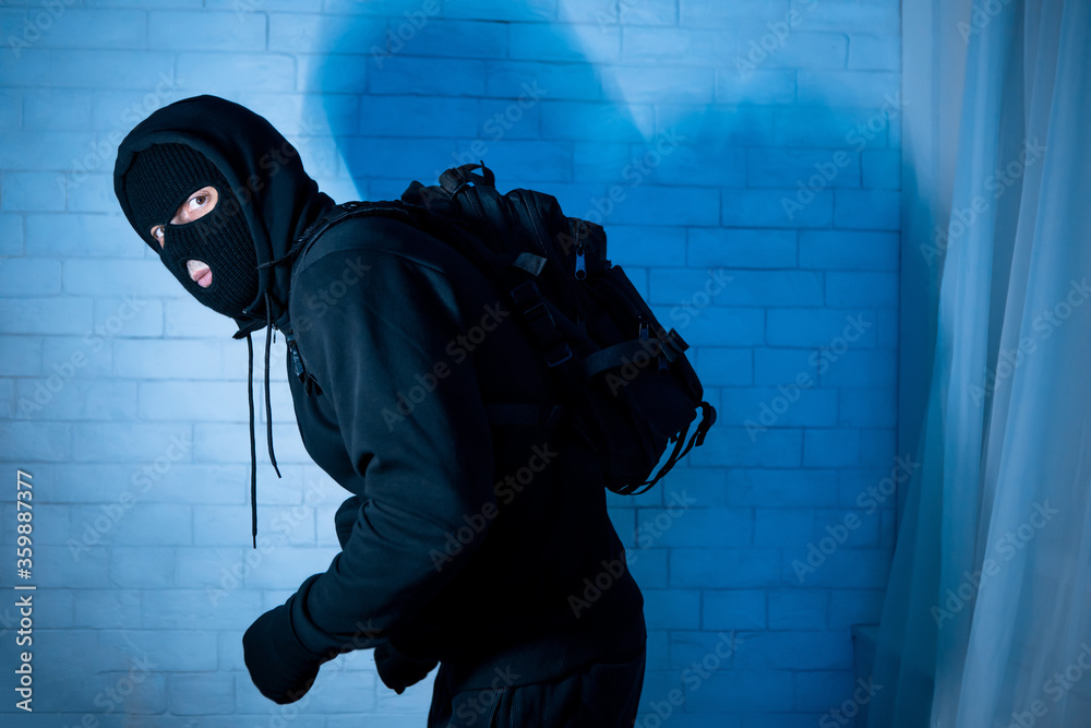 Sneaky robber ready to steal something at home Stock Photo | Adobe Stock