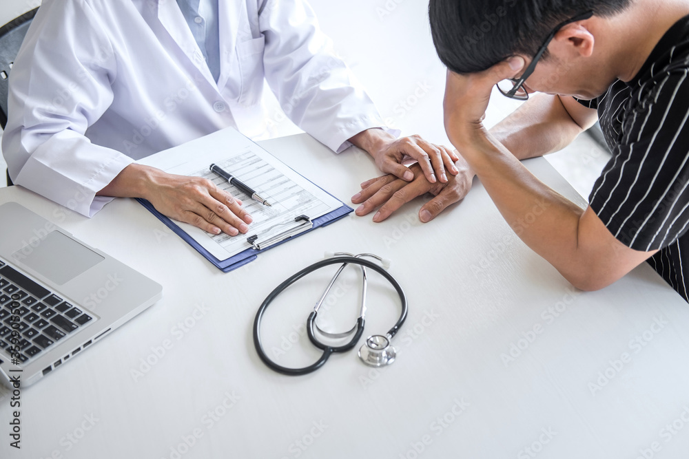 Doctor touching patient hand for encouragement and empathy in the ...