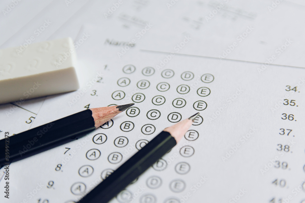 Pencil and eraser on answer sheets or Standardized test form with ...