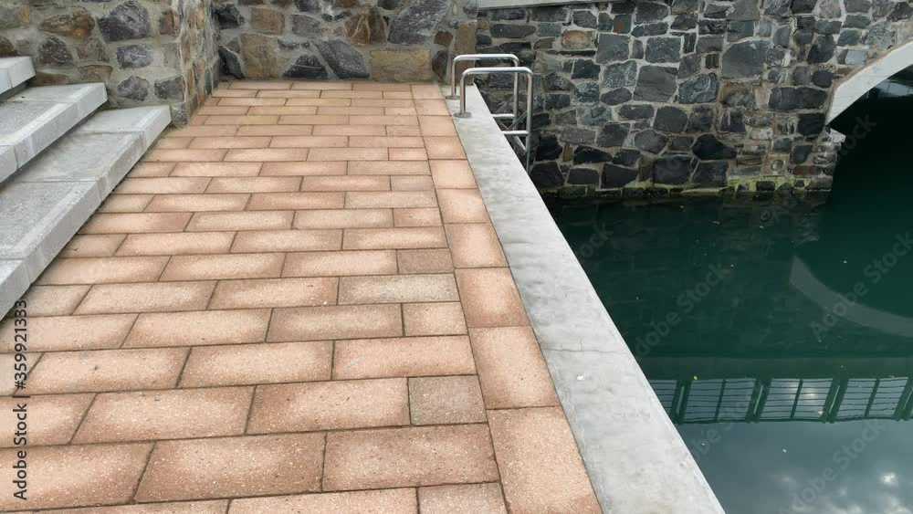 V&A Waterfront canal jetty edge with steps and side view of bridge ...