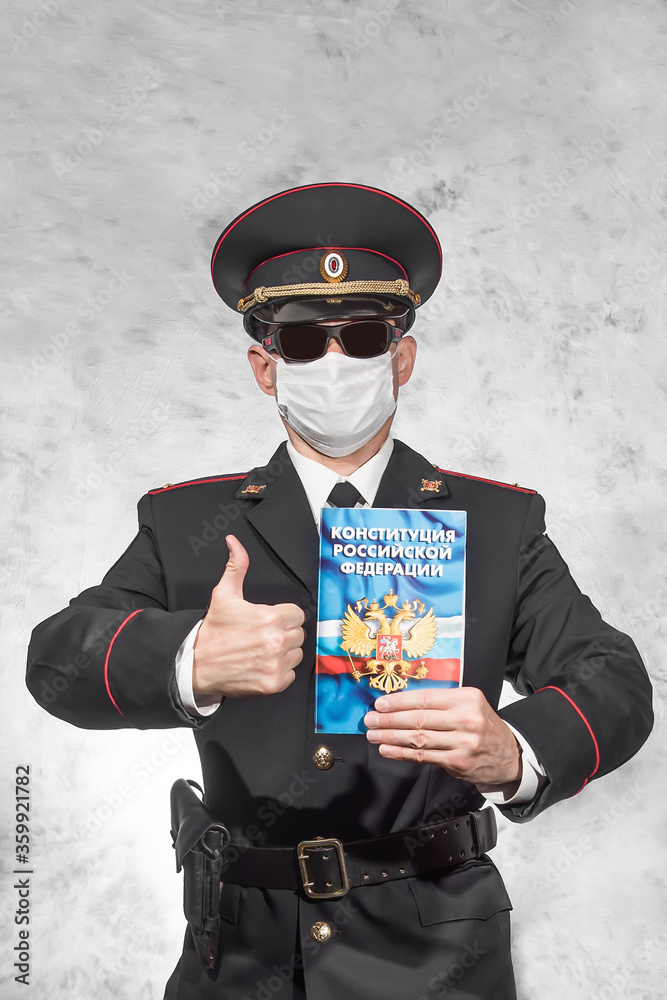 Russian police officer in uniform in a white medical mask and black ...