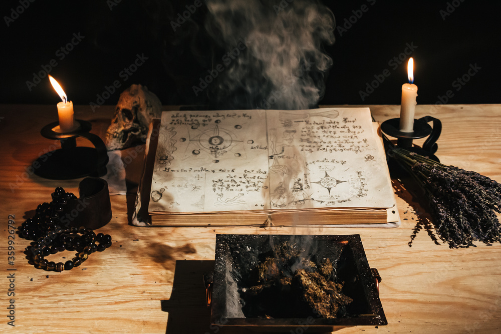 Occult white magic ritual of fire using grimoire, old book, candles ...