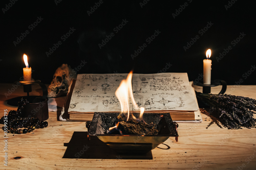 Occult white magic ritual of fire using grimoire, old book, candles ...