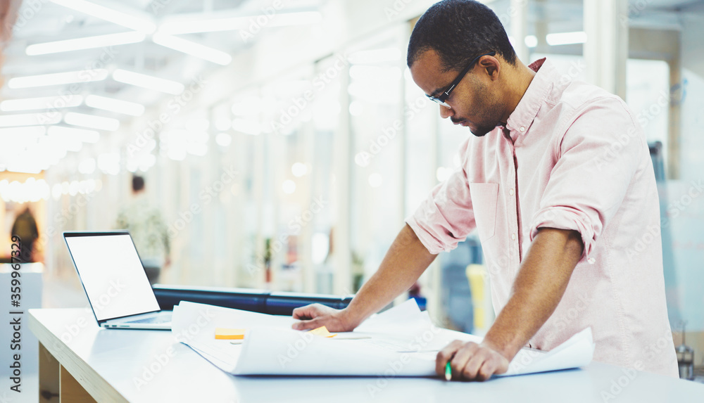 Pensive male engineer making blueprint for city planning drawing new ...