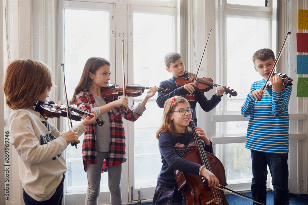 Group of children playing violin during a lesson Stock Photo | Adobe Stock