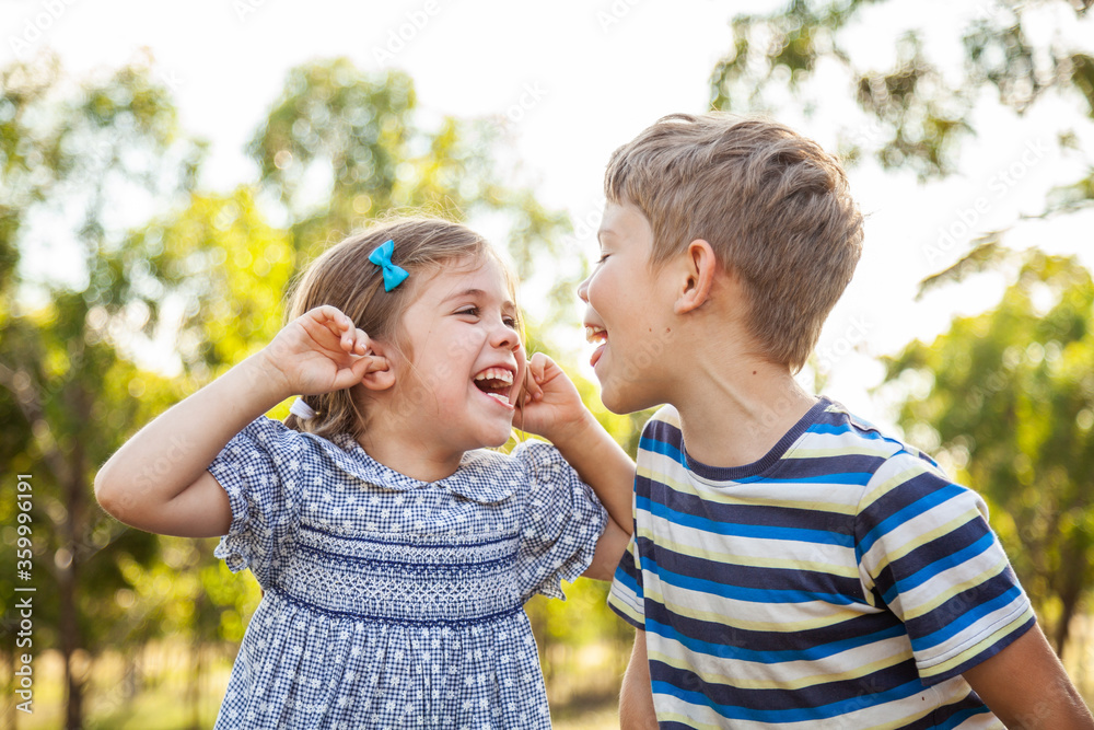 Kids being silly together - boy shouting and roaring at little girl ...